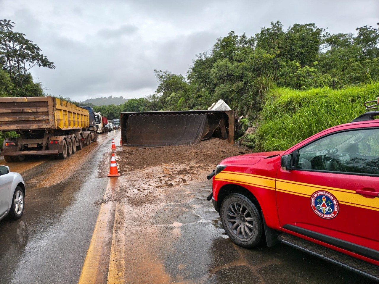 Carreta carregada de terra tomba na BR-381, deixa motorista ferid